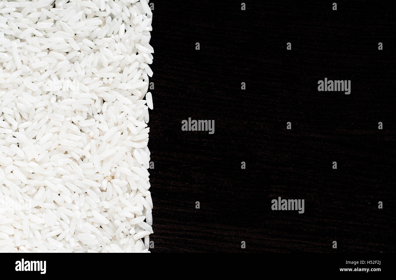 White uncooked rice on a dark background Stock Photo - Alamy