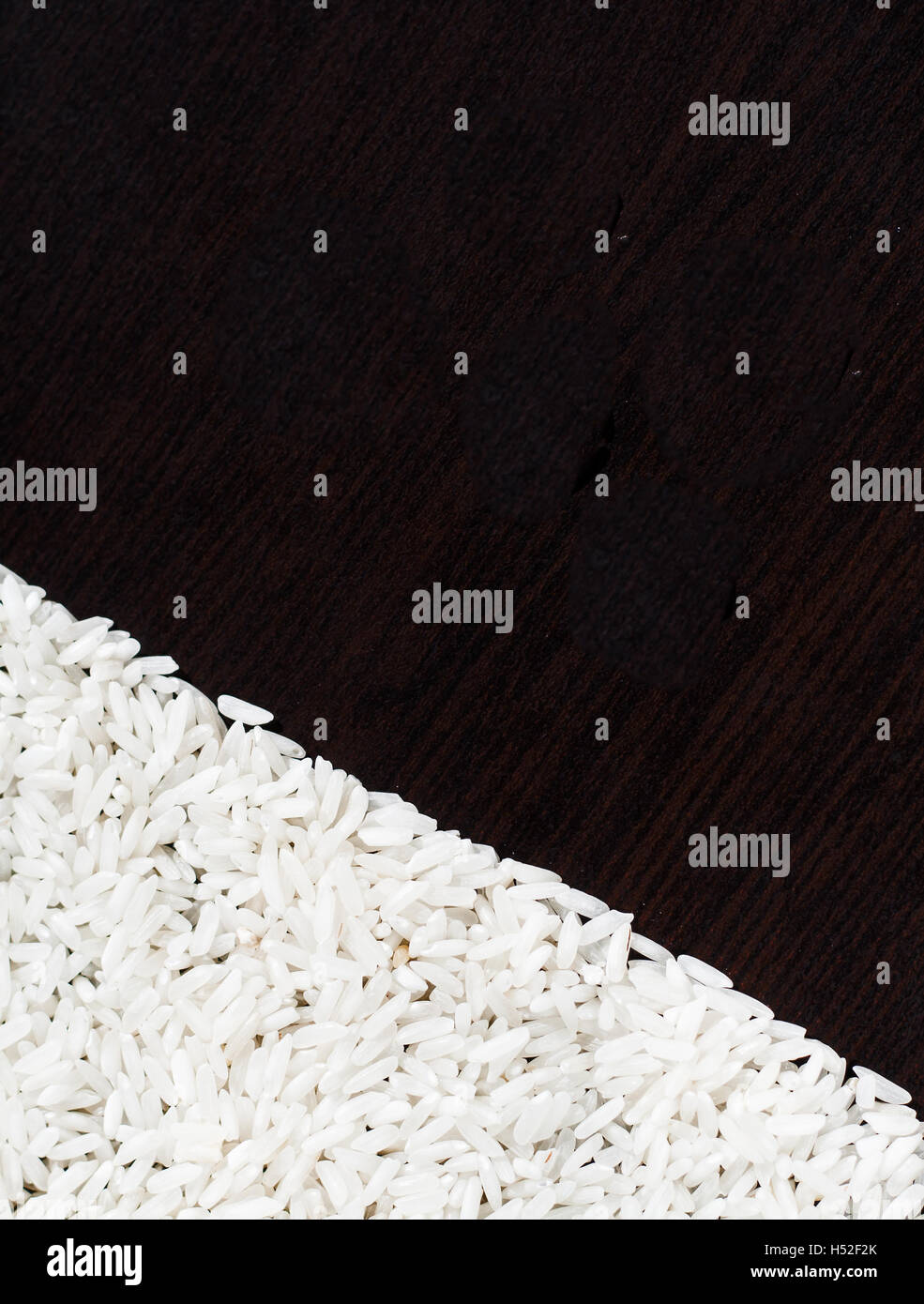 White uncooked rice on a dark background Stock Photo - Alamy