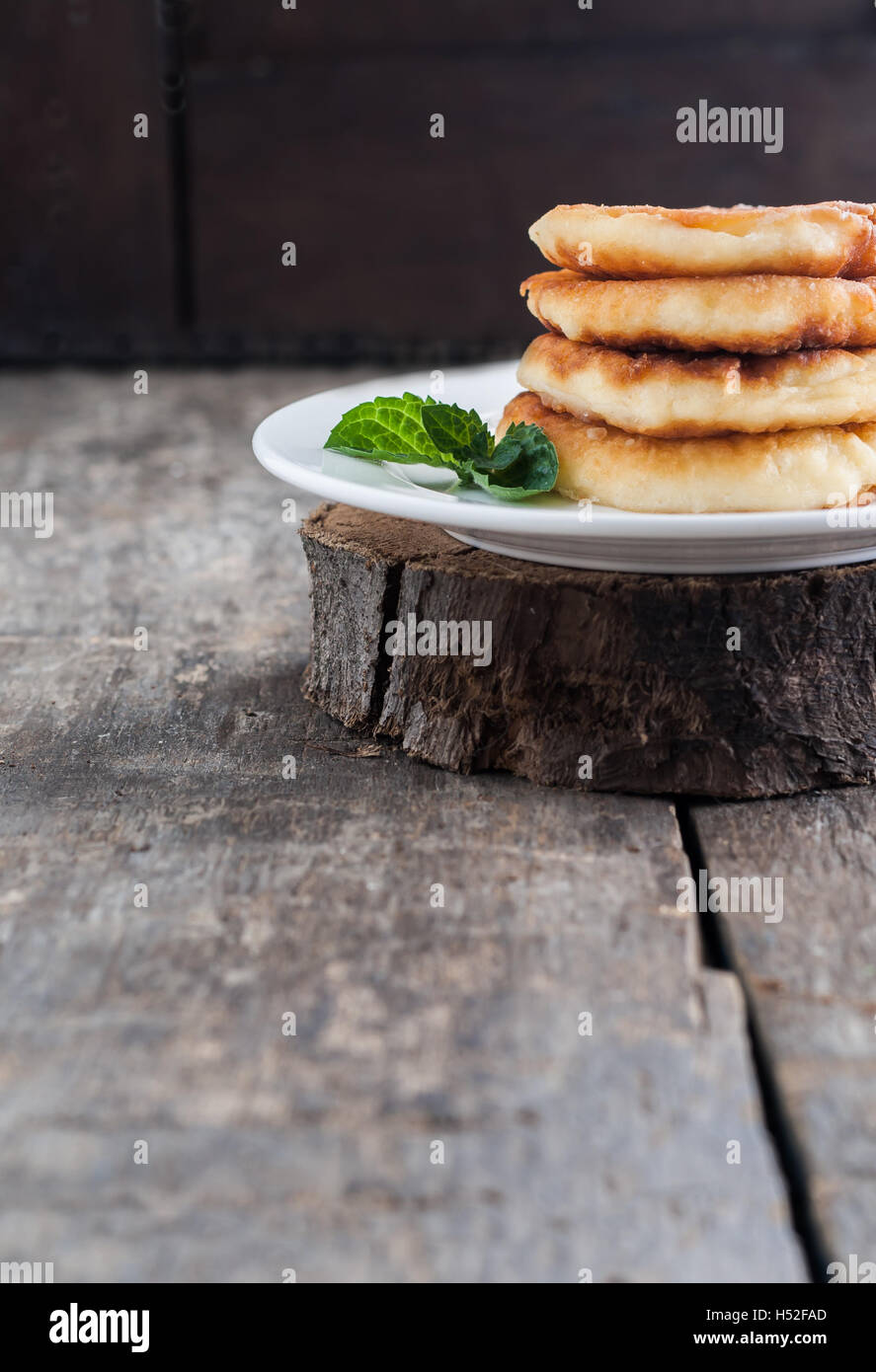 stack of cheesecakes on a white plate and a dark wooden background ...