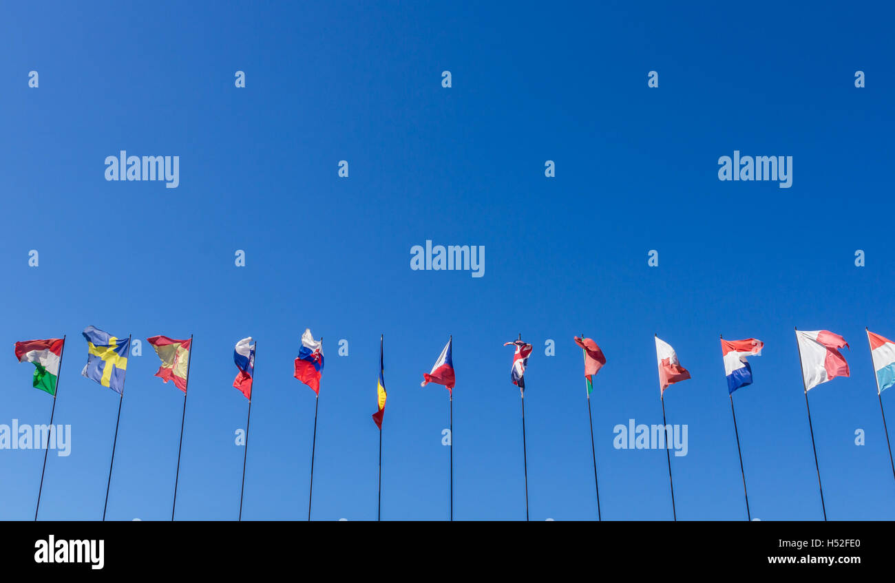 Row of national flags against blue sky Stock Photo - Alamy