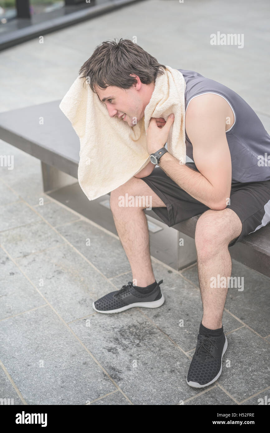 Young handsome caucasian brown hair sportive man drying himself with a ...
