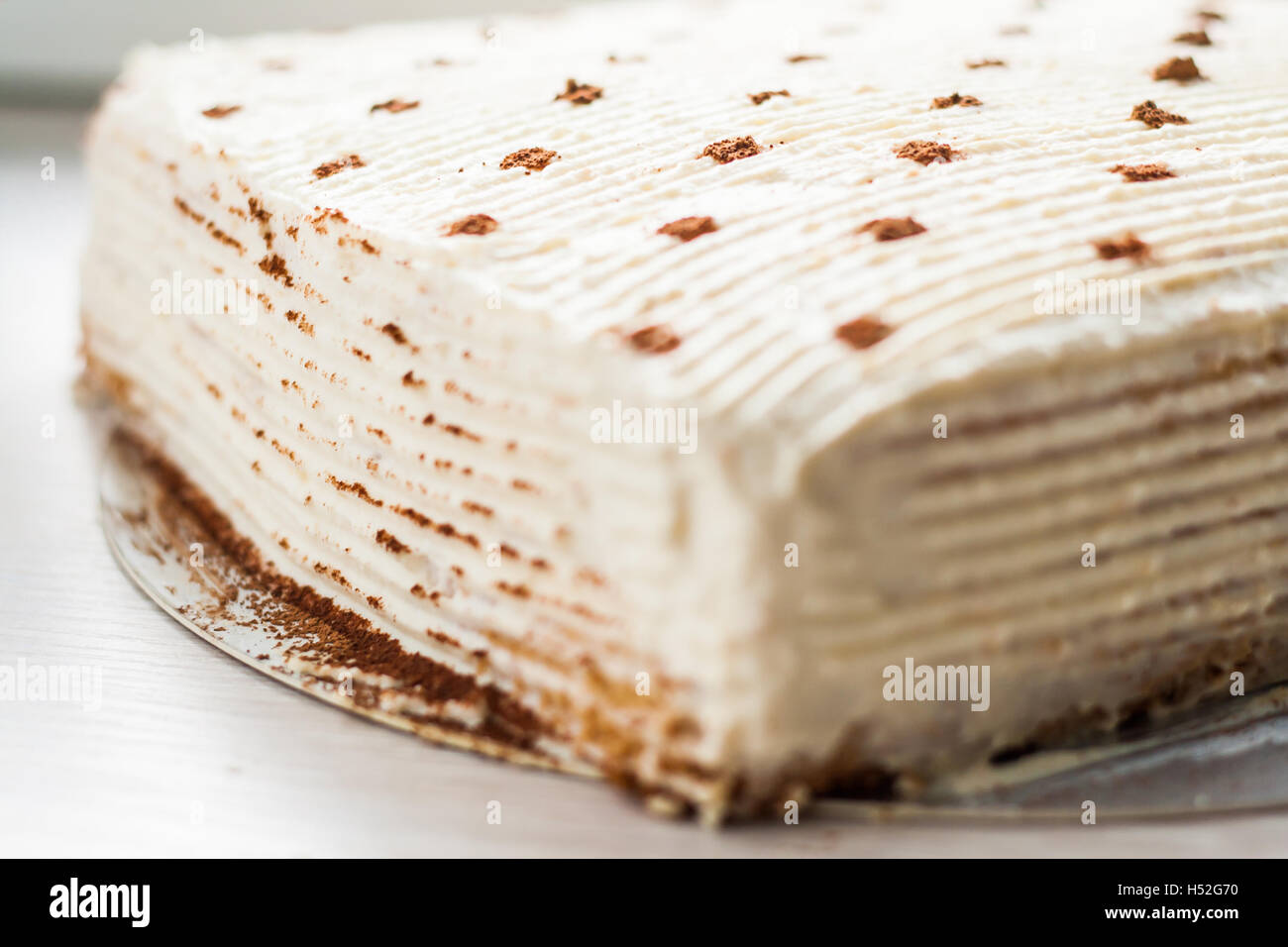 Angle square cream cake decorated with cocoa Stock Photo - Alamy
