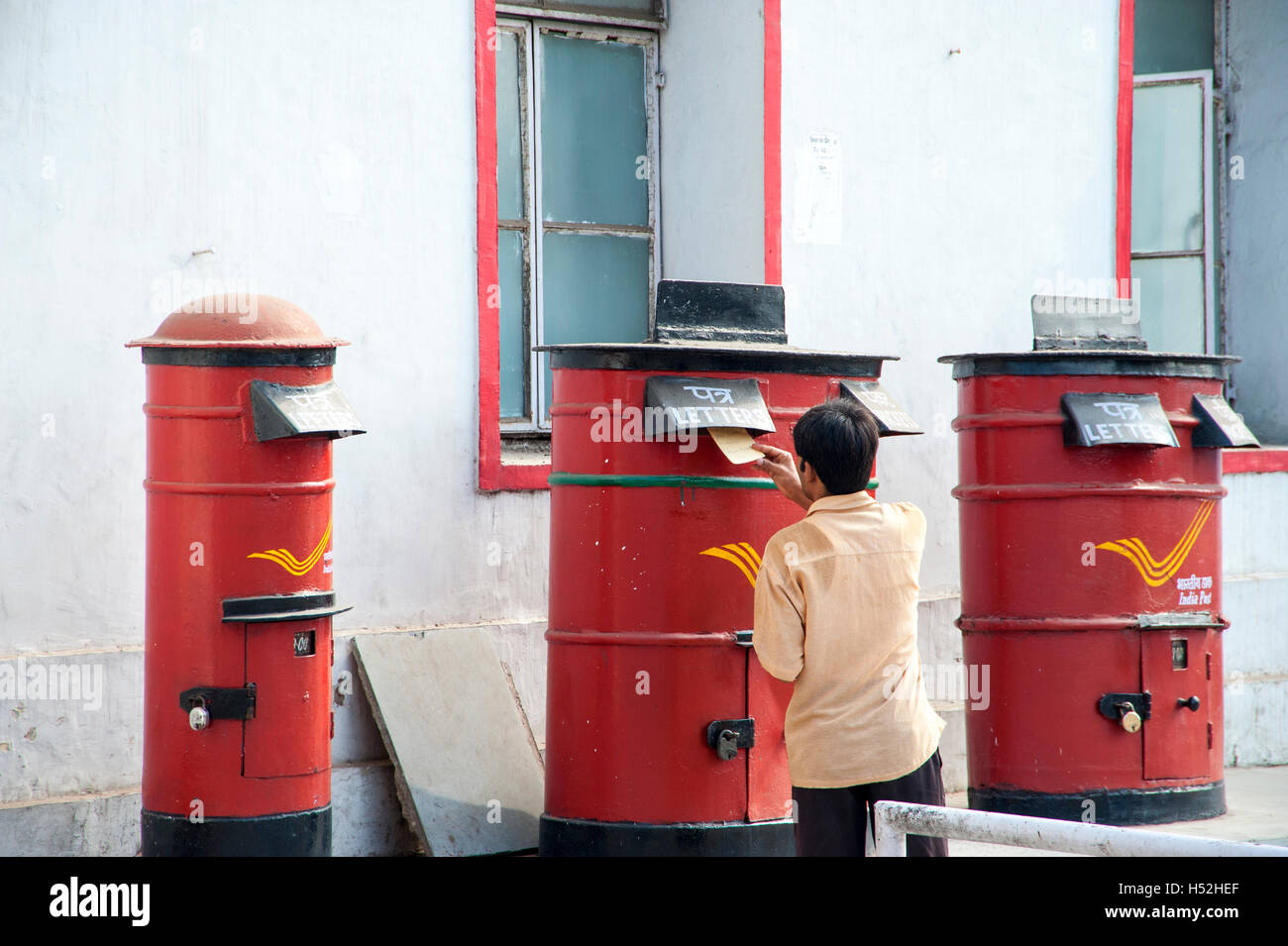 Man posting letter in middle of three post boxes outside the General ...