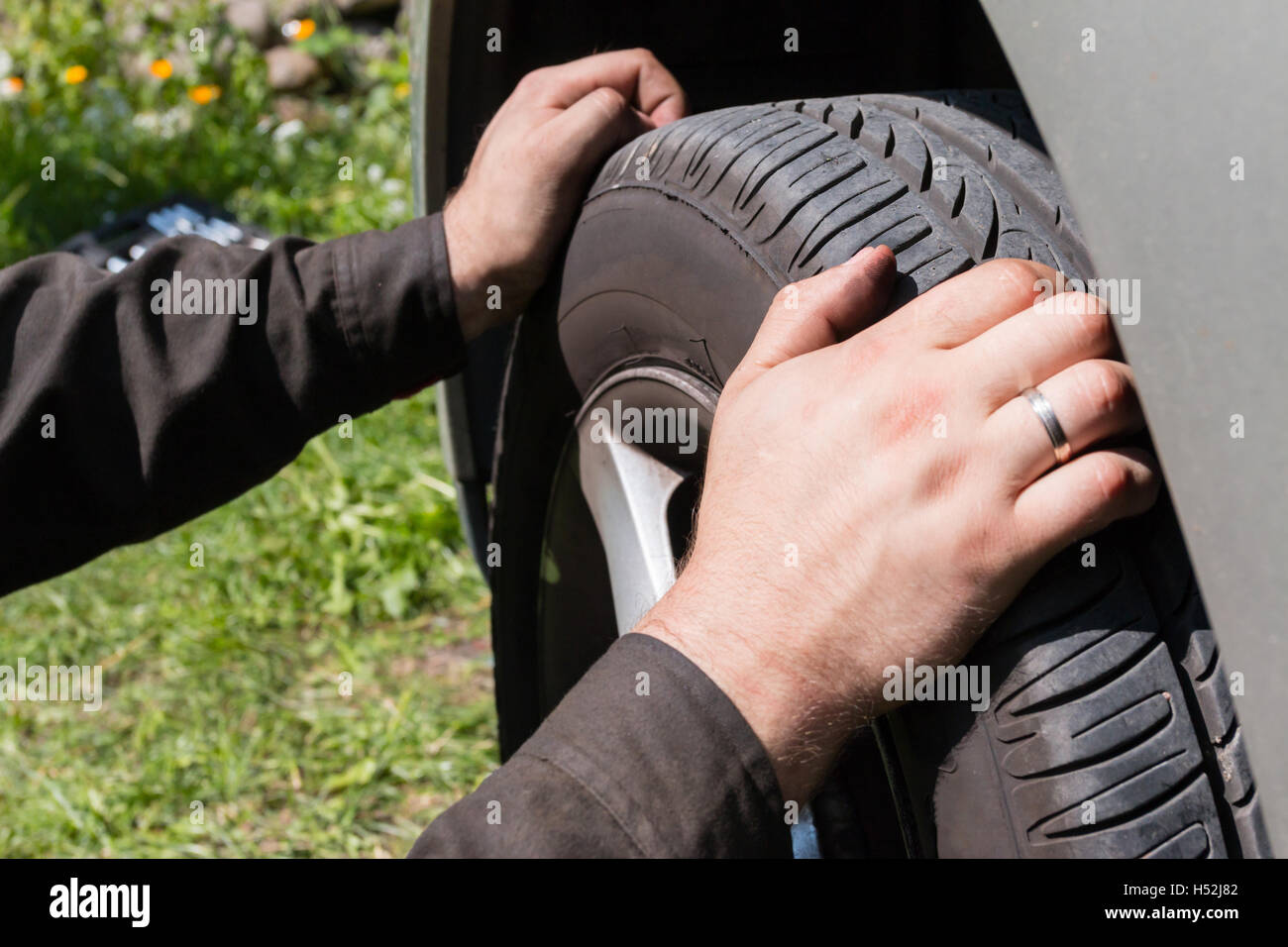 Mechanic checking tyre Stock Photo - Alamy