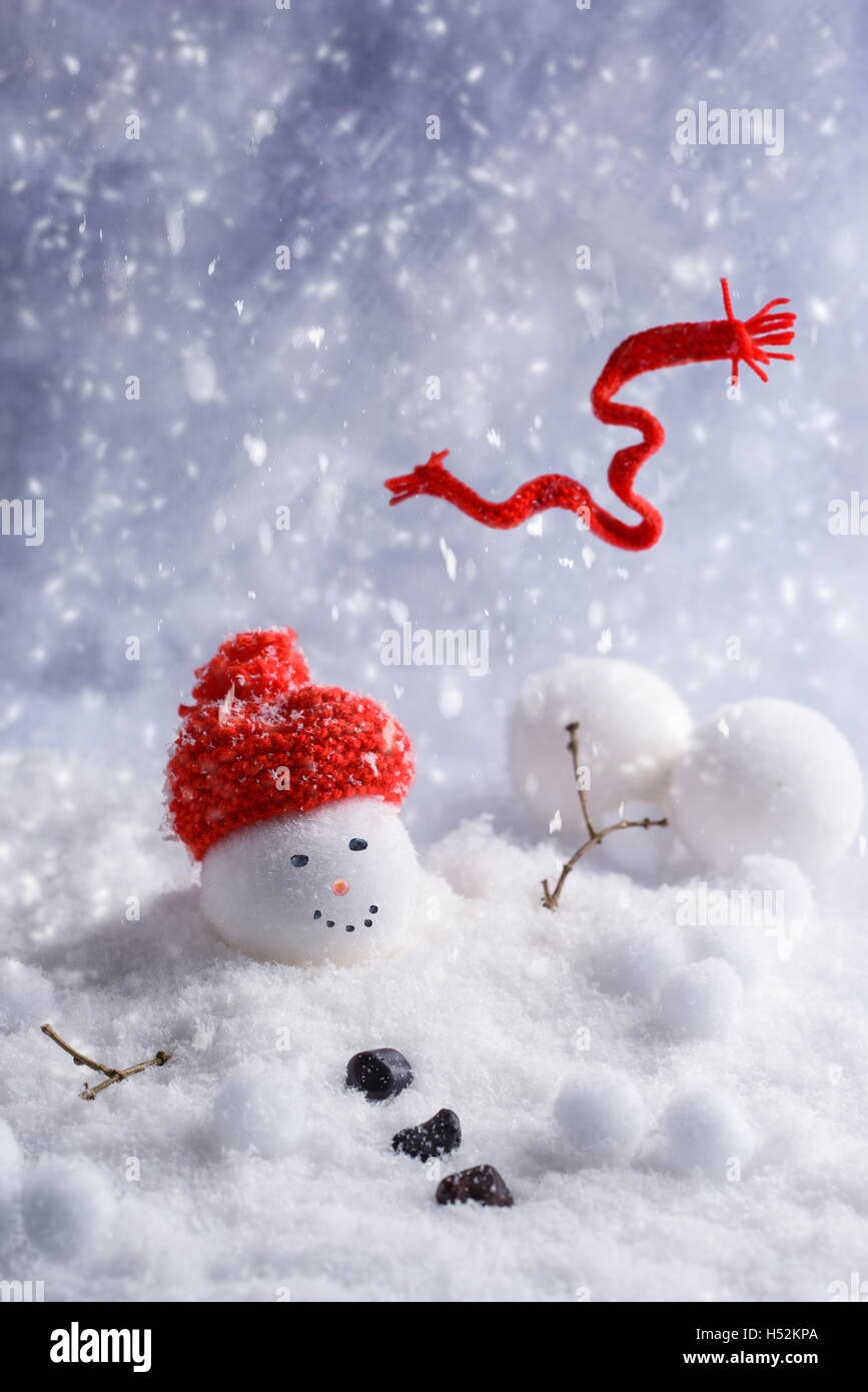 Melting snowman with red knitted scarf blowing in the wind Stock Photo ...