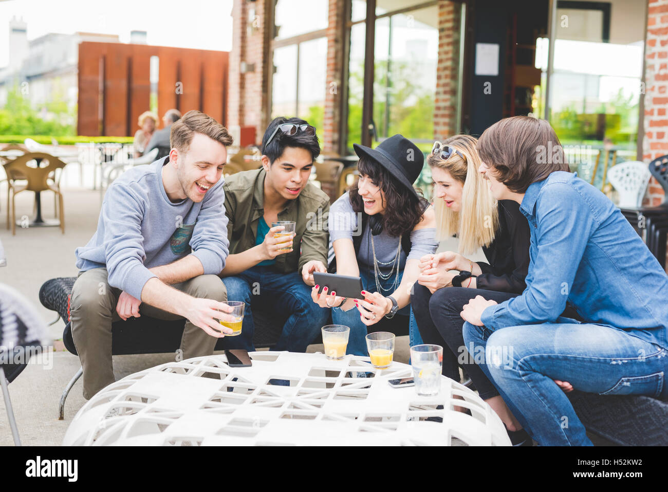 Group of young multiethnic friends sitting in a bar having a drink ...