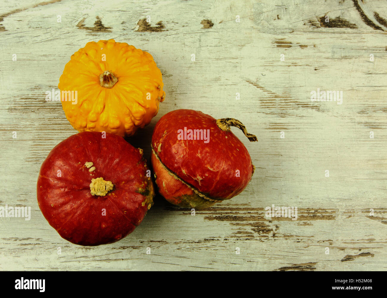Three decorative pumpkins, two red and one yellow light on the old ...