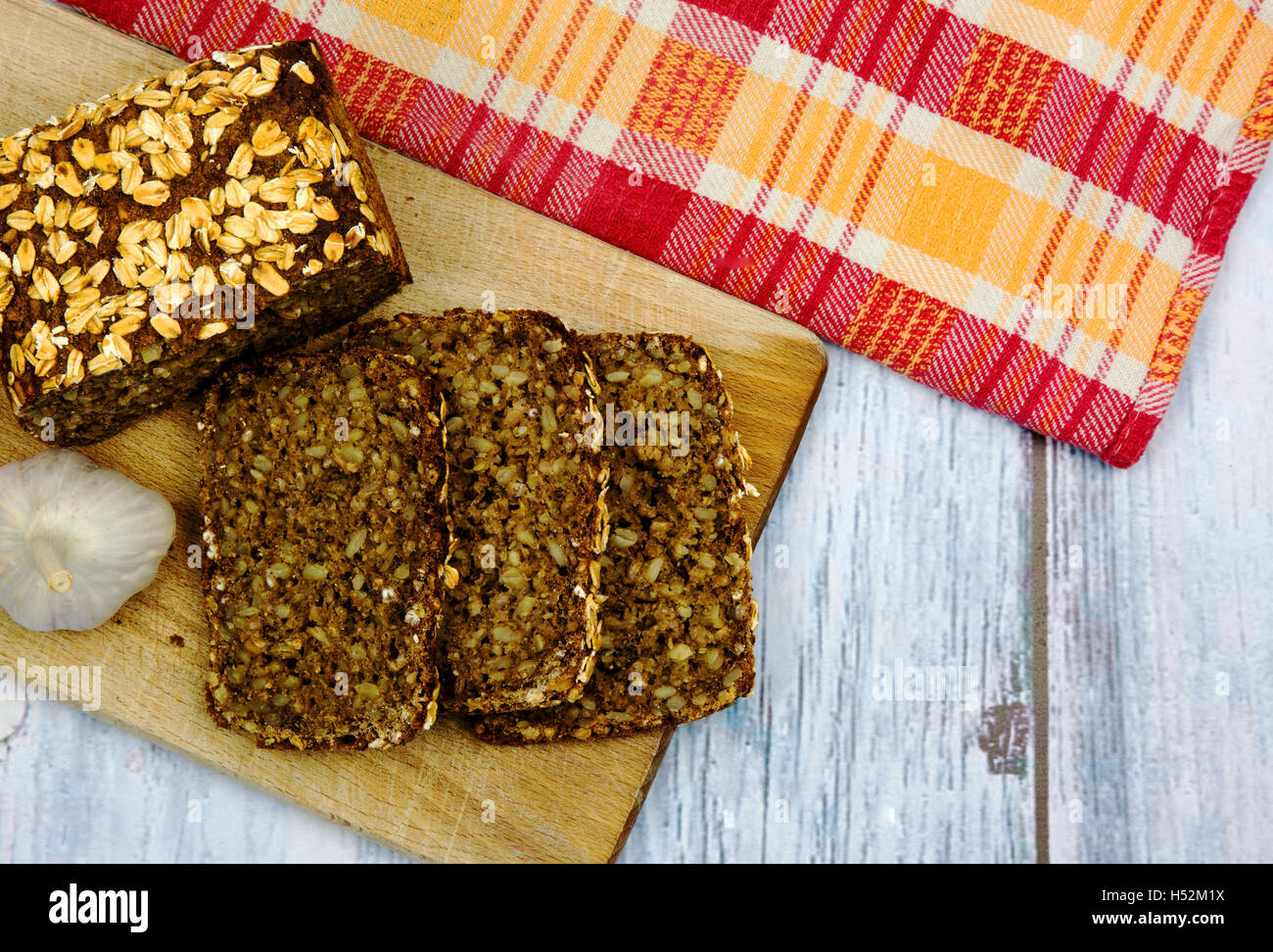 Flat top view of a loaf and a couple of slices of bread with grains and ...