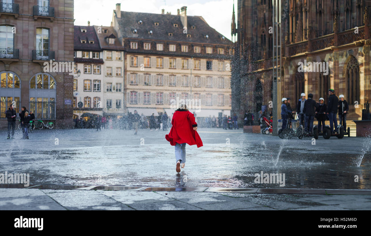 Cute little girl playing in water splash of street fountain, Strasbourg ...