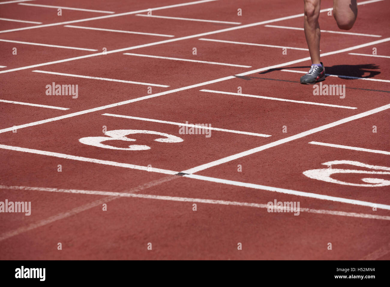 Male runner finalizing a race in a running track. Horizontal Stock ...
