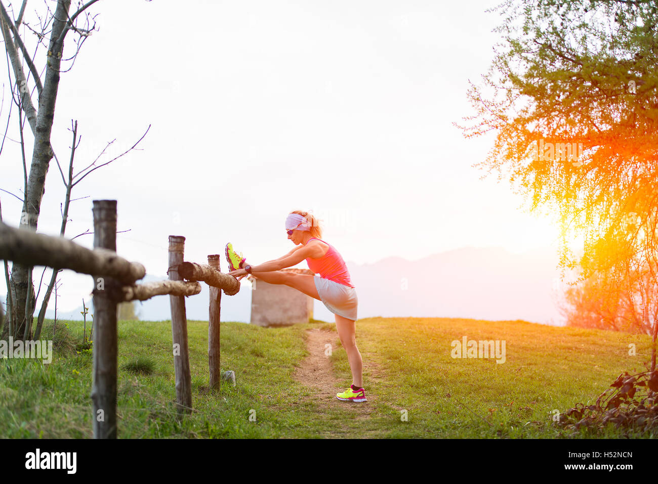 Girl makes stretching in the nature of a fence Stock Photo - Alamy