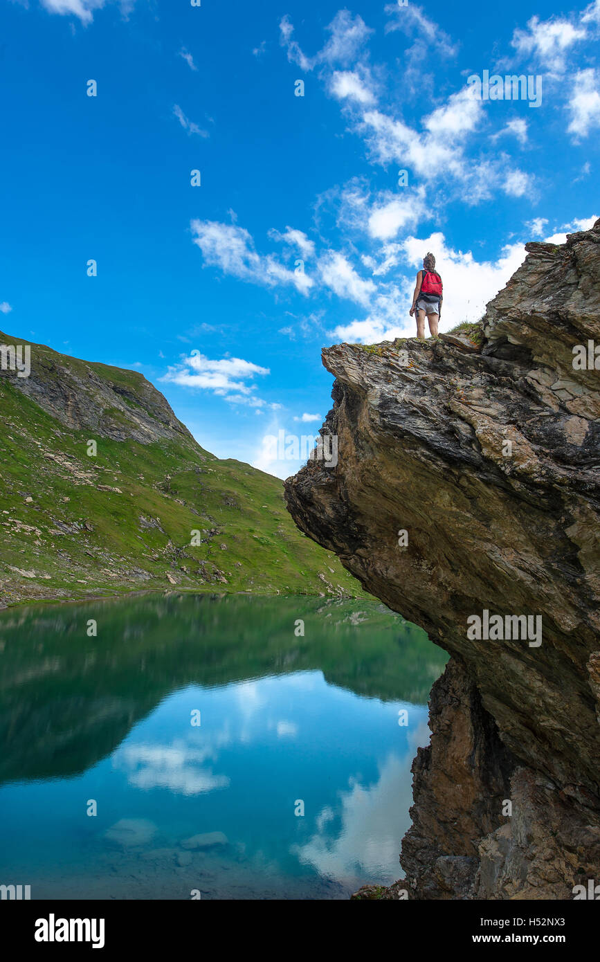 Girl on a rock above an alpine lake Stock Photo - Alamy