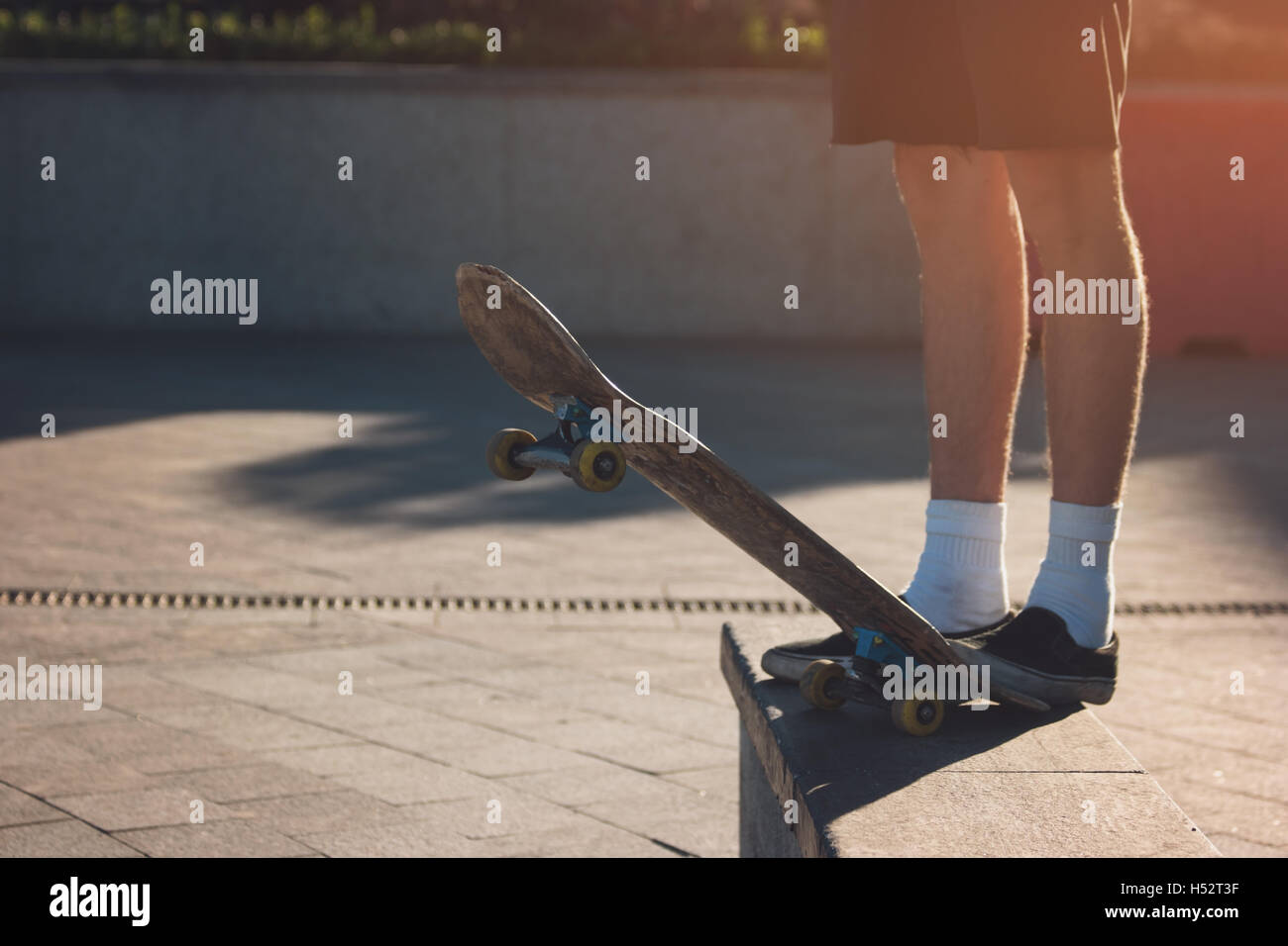 Foot standing on skateboard. Skateboarder wearing shorts. Skateboarding ...