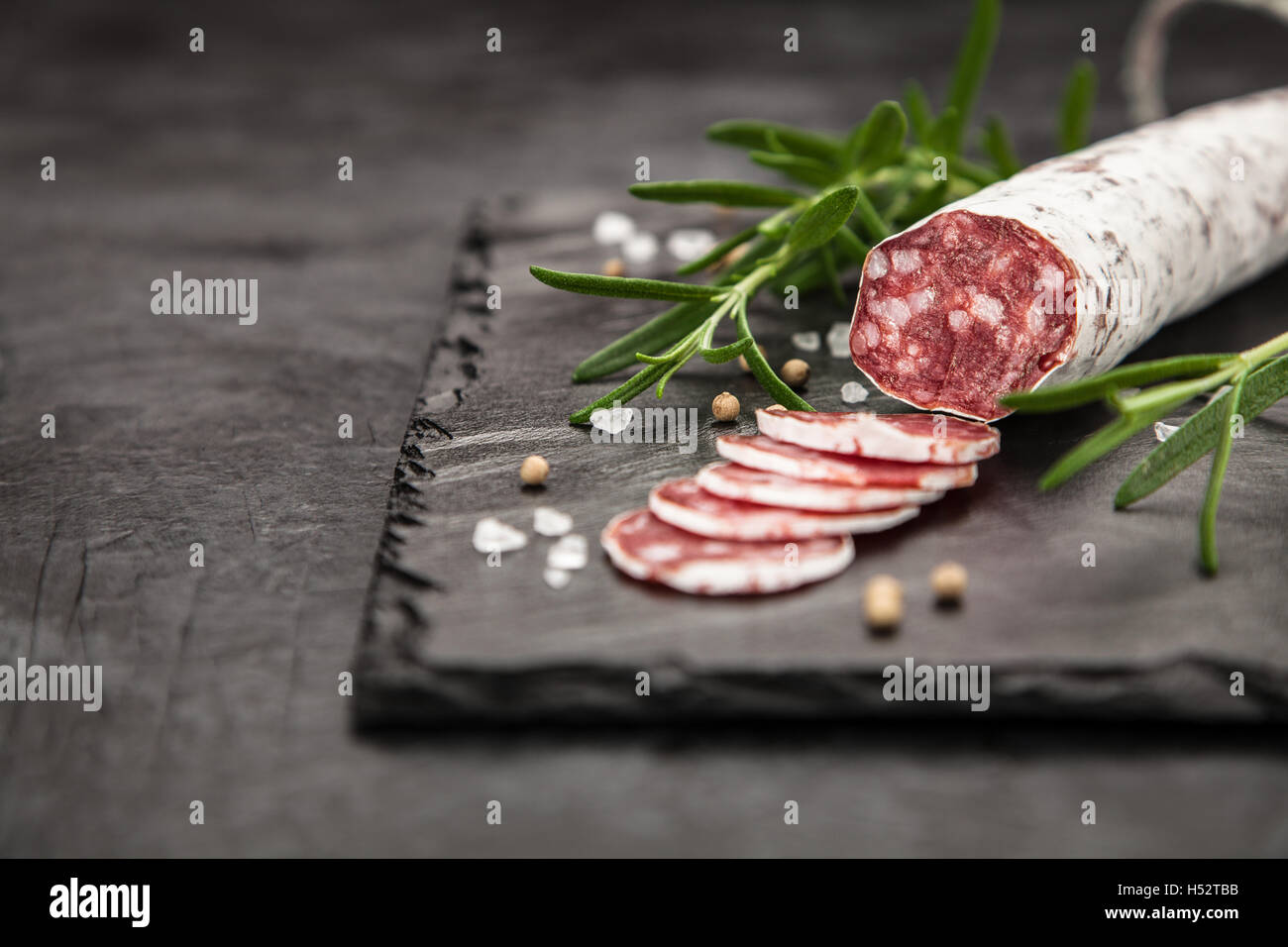 Salami on dark background Stock Photo - Alamy
