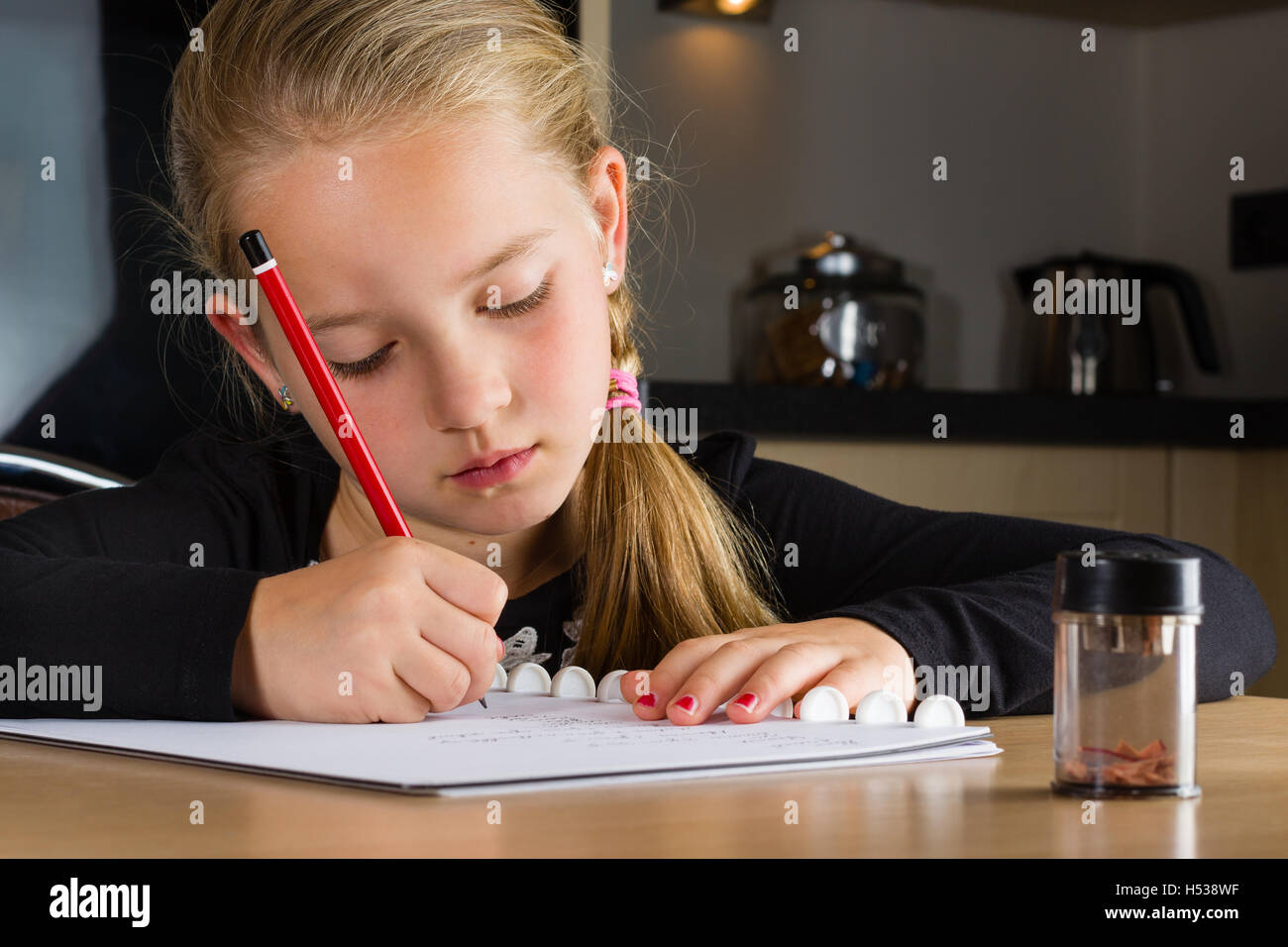 Girl doing homework at the kitchen table Stock Photo - Alamy