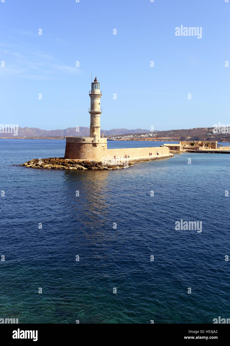 A view of Chania lighthouse in Crete, Greece, with the mountains of the ...