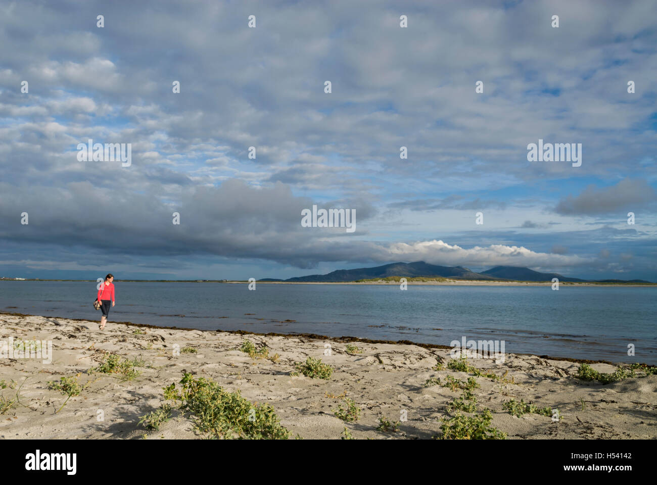 Female paddlling in the sea along Liniclate Beach on Benbecula with ...