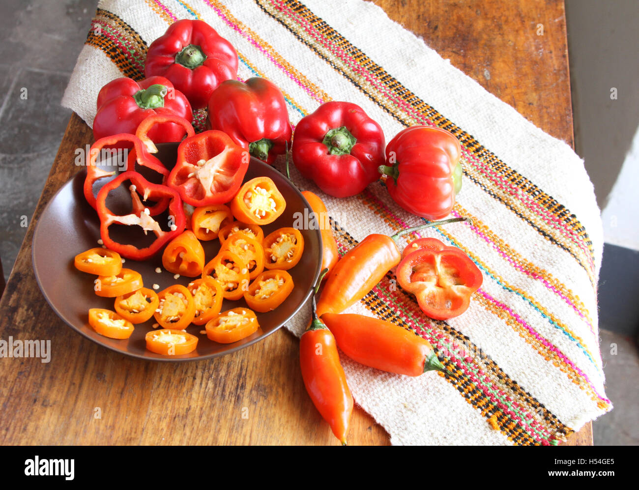 Whole and sliced red and orange chili peppers on table in Peru Stock ...