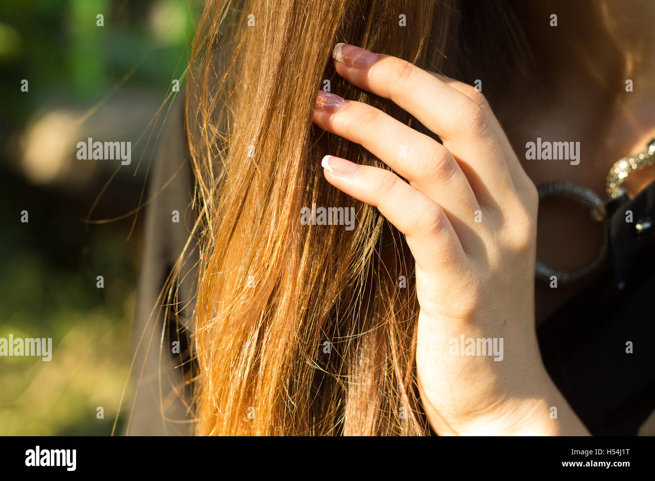 Woman's touching long hair Stock Photo - Alamy
