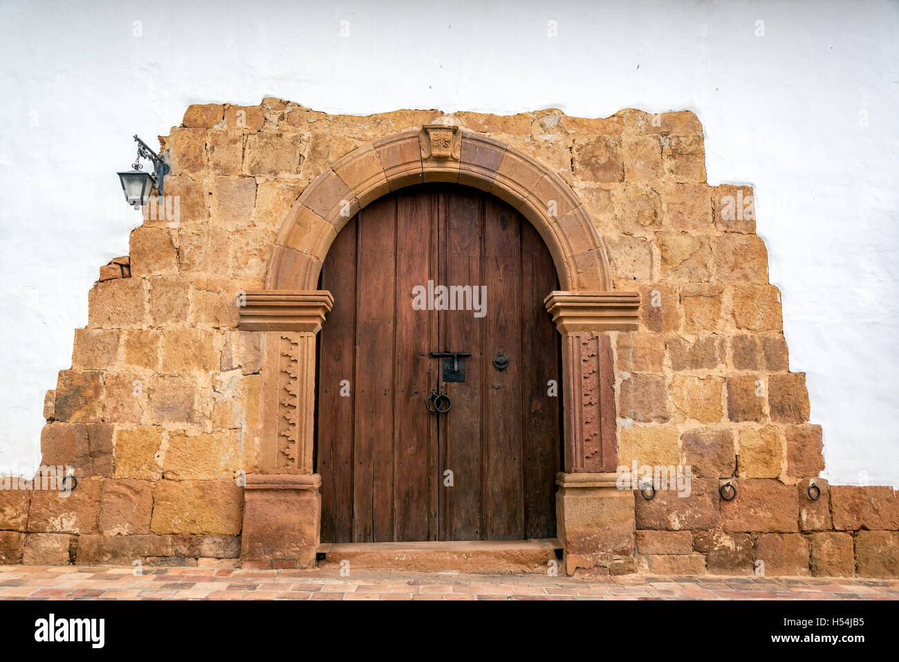 Wooden door on a colonial building with a stone arch in Barichara ...