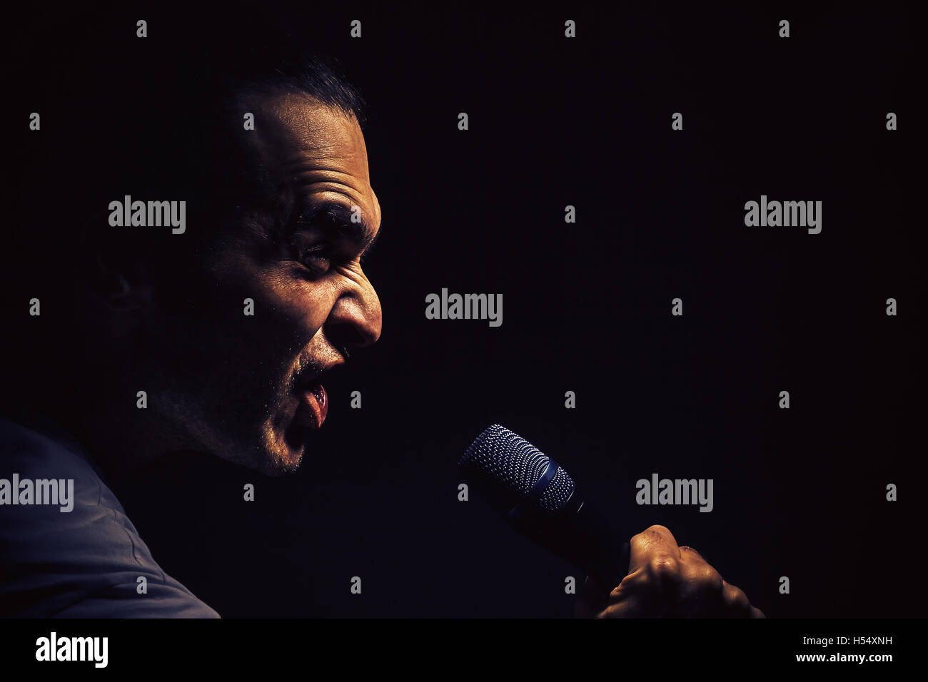 Act of a man with microphone, angry facial expression Stock Photo - Alamy