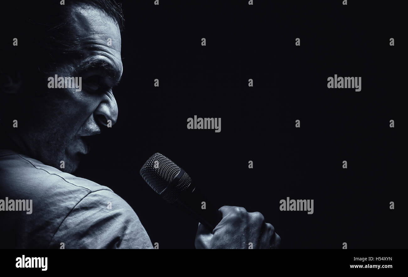 Act of a man with microphone, angry facial expression Stock Photo - Alamy