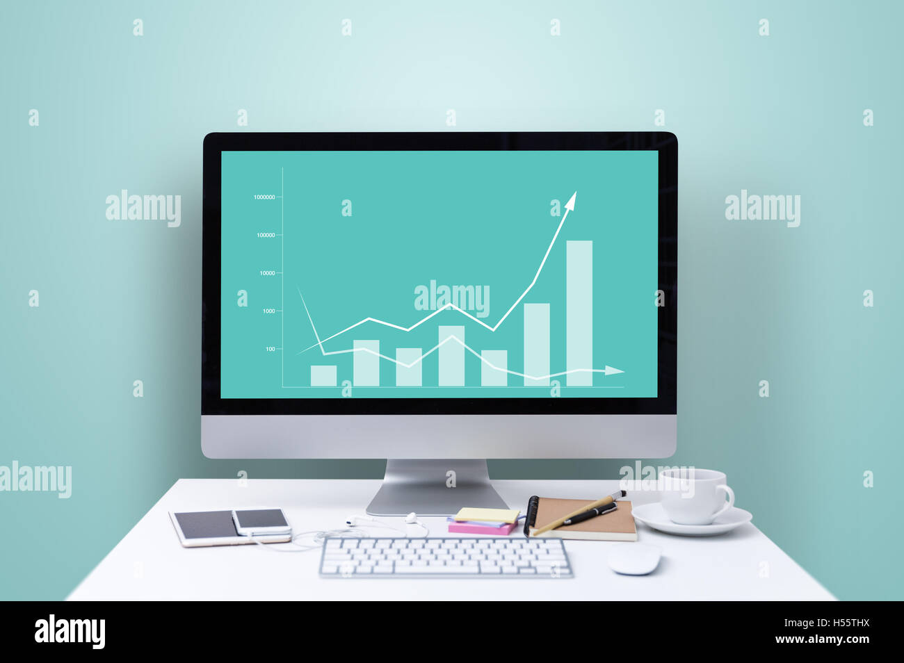 office desk with stationary. Business Graph on screen Stock Photo - Alamy