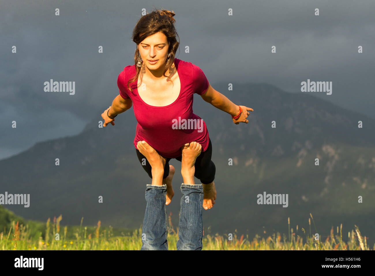 Positions Acroyoga girl of male in nature in the mountains Stock Photo ...