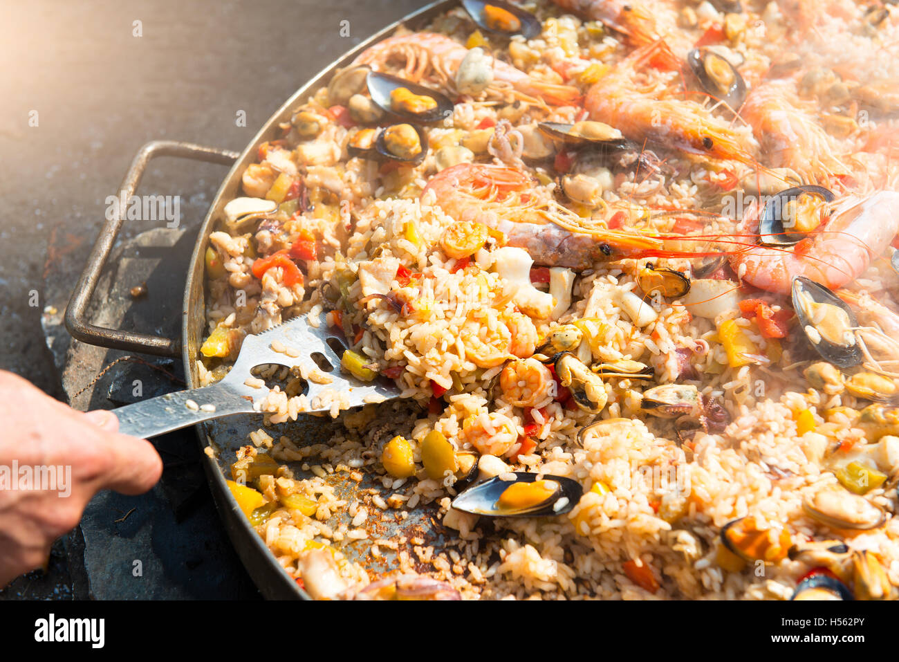Preparing Paella rice and fish in outodoor Stock Photo - Alamy