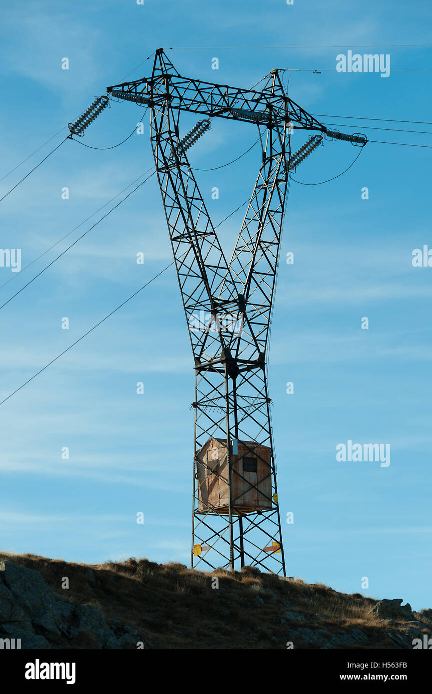 A curious electricity pylon with inside a small house Stock Photo - Alamy