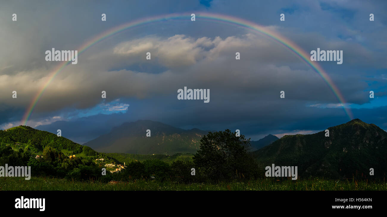 Real rainbow above a small village in the mountains at sunset Stock ...