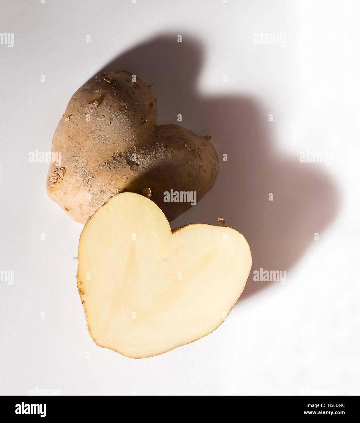 Heart shaped potato cut in half, on a white background Stock Photo - Alamy