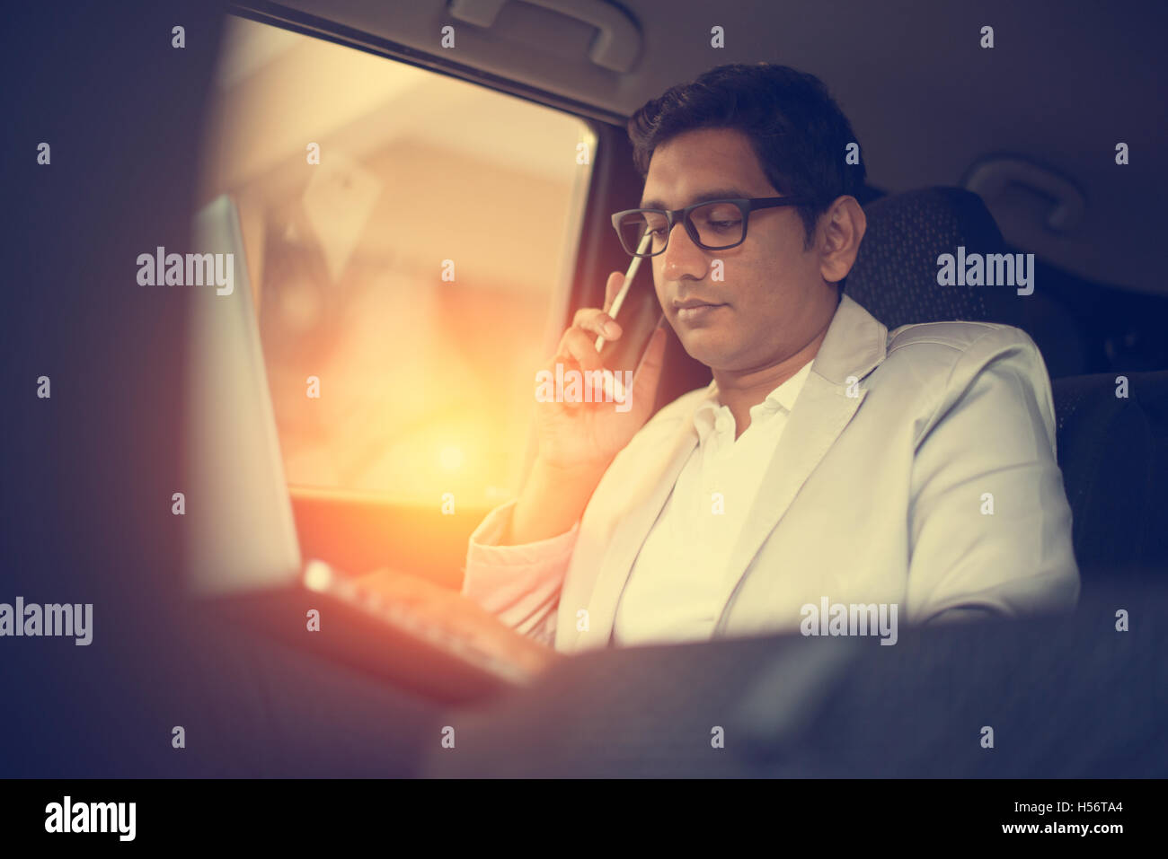 indian business male using laptop and phone inside the car Stock Photo ...