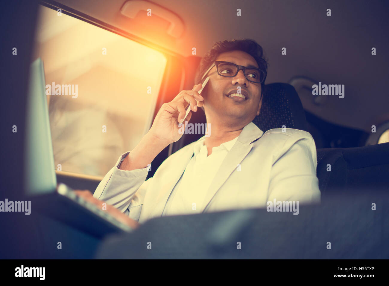indian business male using laptop and phone inside the car Stock Photo ...