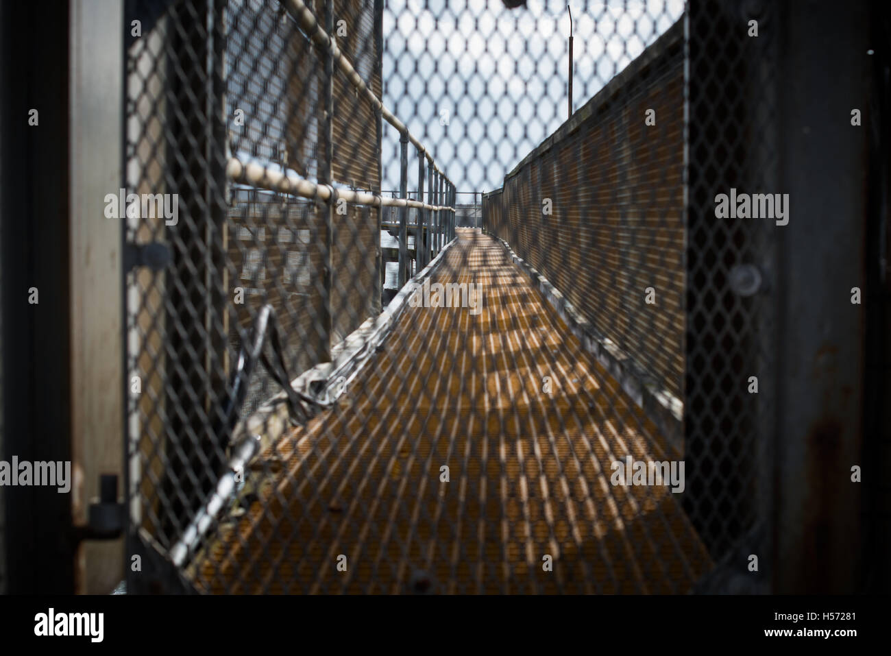 A closed wire mesh fence denies access to a walkway and maintenance ...