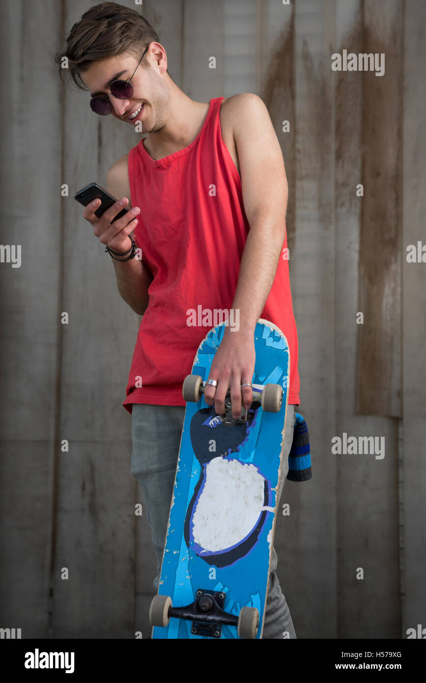 Teenage skater boy using smartphone wifi connected. Teenager portrait ...