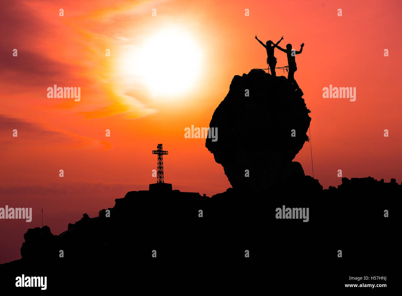 Team of climbers conquer the summit in teamwork during a climb roped in ...