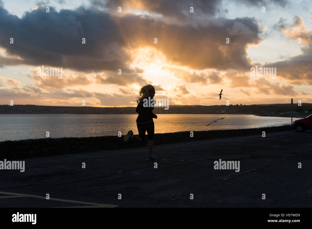A girl running at sunset Stock Photo - Alamy