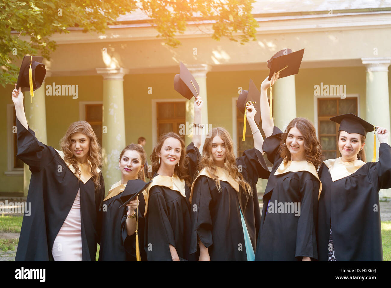 Graduate students wearing graduation hat and gown, outdoors Stock Photo ...