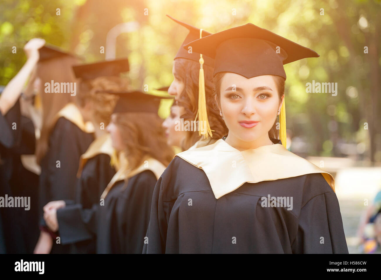 Graduate students wearing graduation hat and gown, outdoors Stock Photo ...