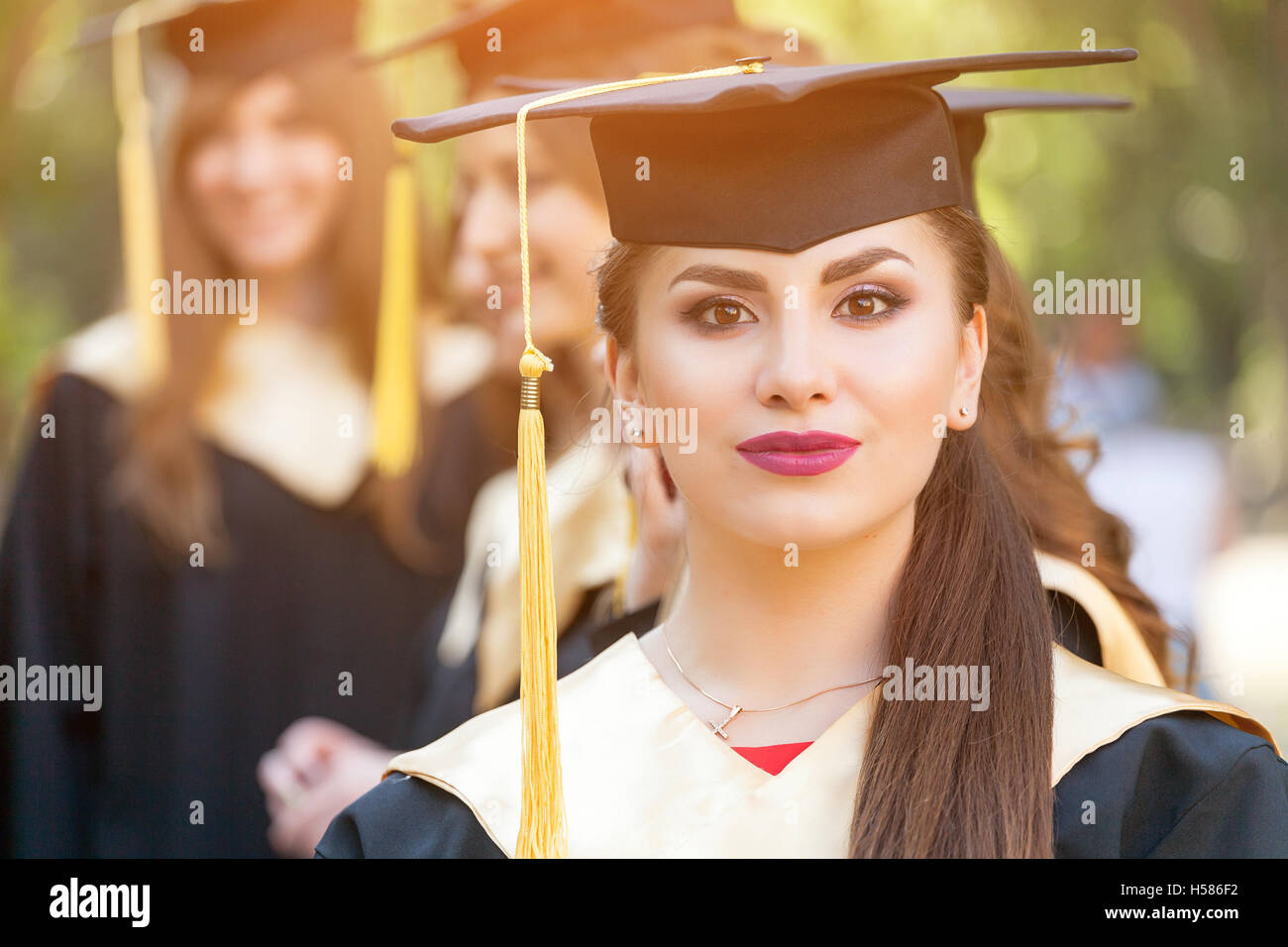 Graduate students wearing graduation hat and gown, outdoors Stock Photo ...