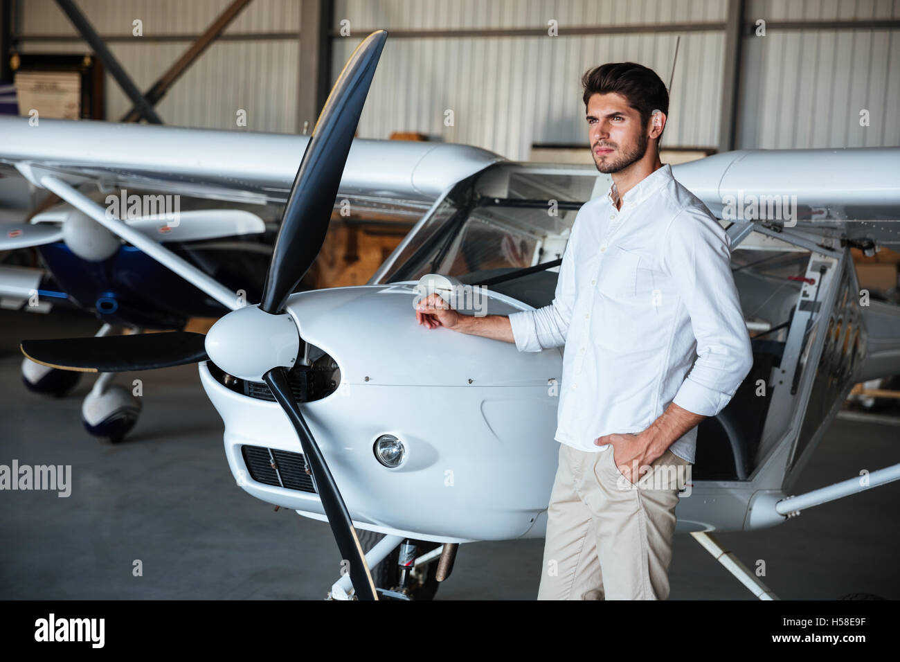 Serious handsome young man standing near small airplane Stock Photo - Alamy