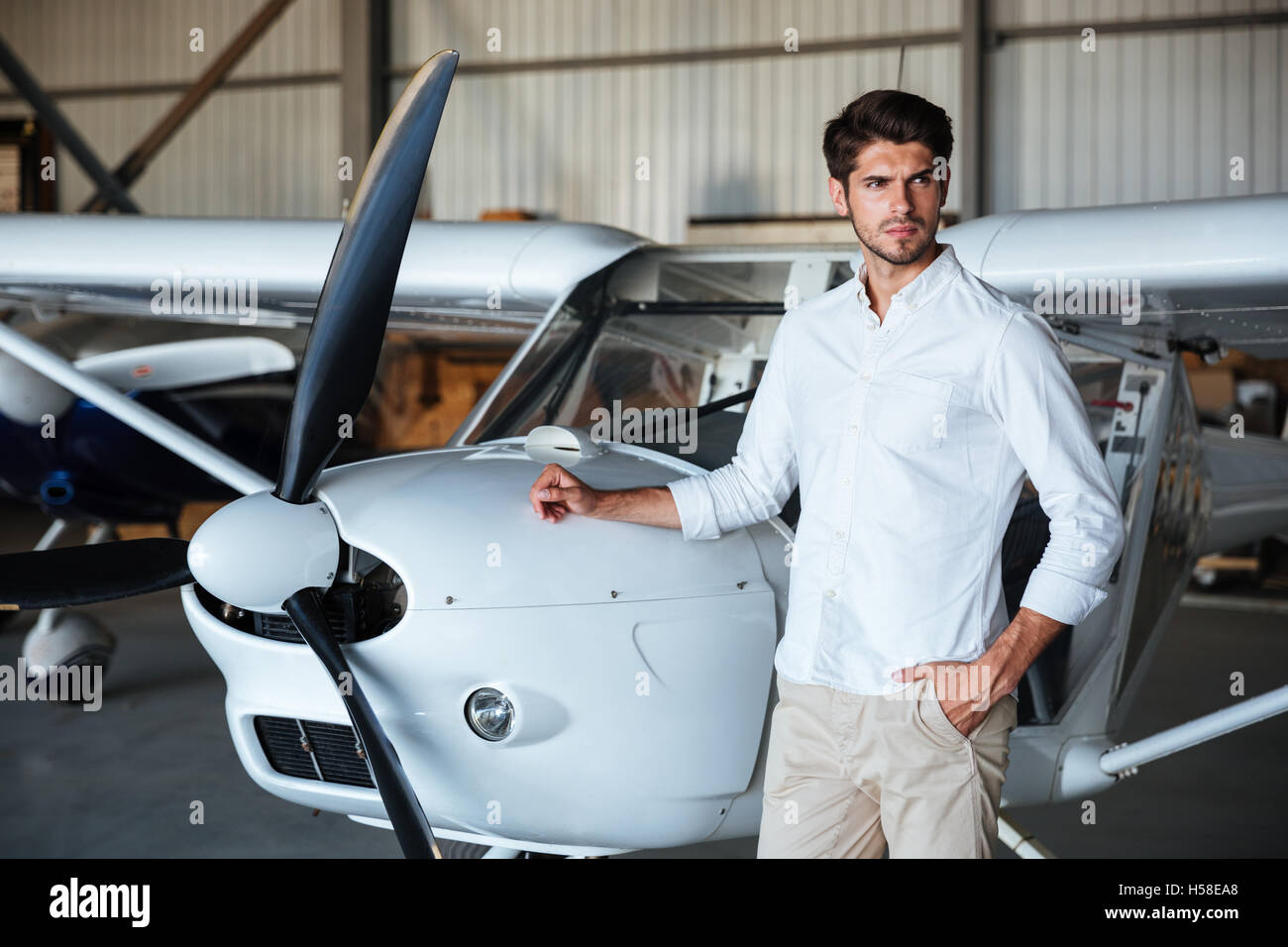 Portrait of attractive young man standing near small aircraft Stock ...