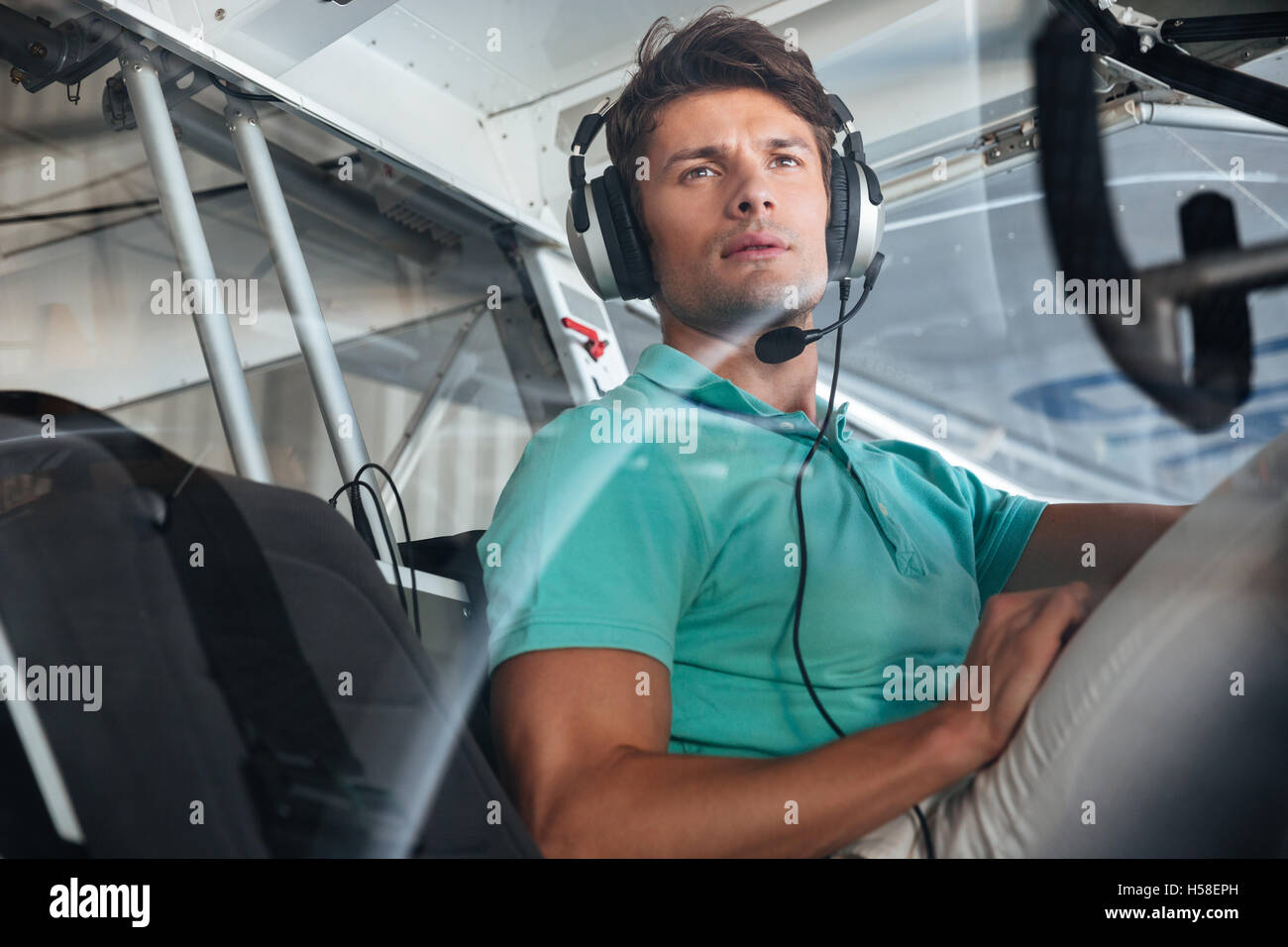 Portrait of serious young man pilot in cabin of private aircraft Stock ...