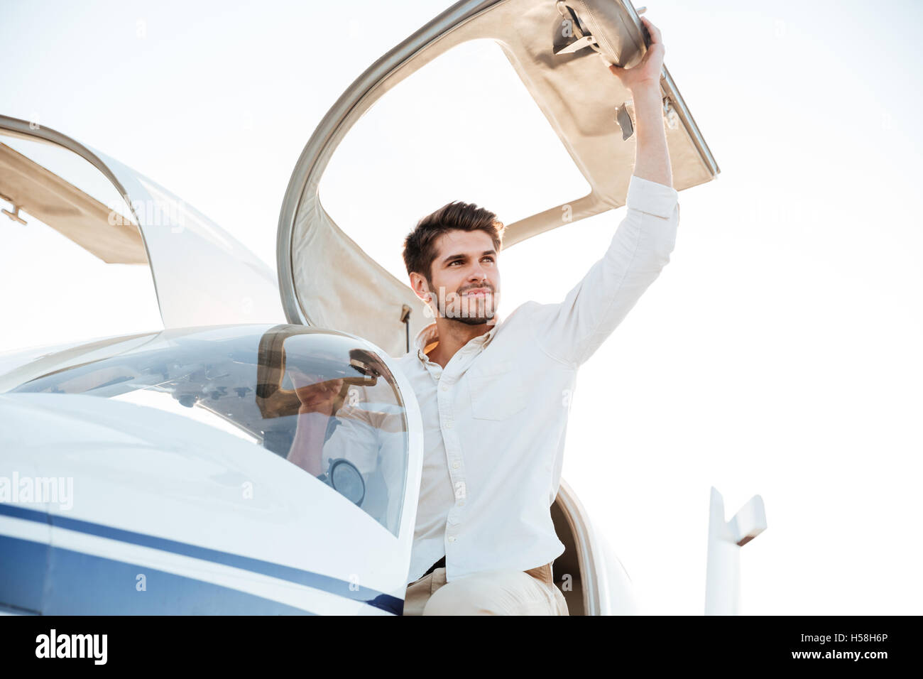 Cheerful young man pilot getting out of the plane after landing Stock ...