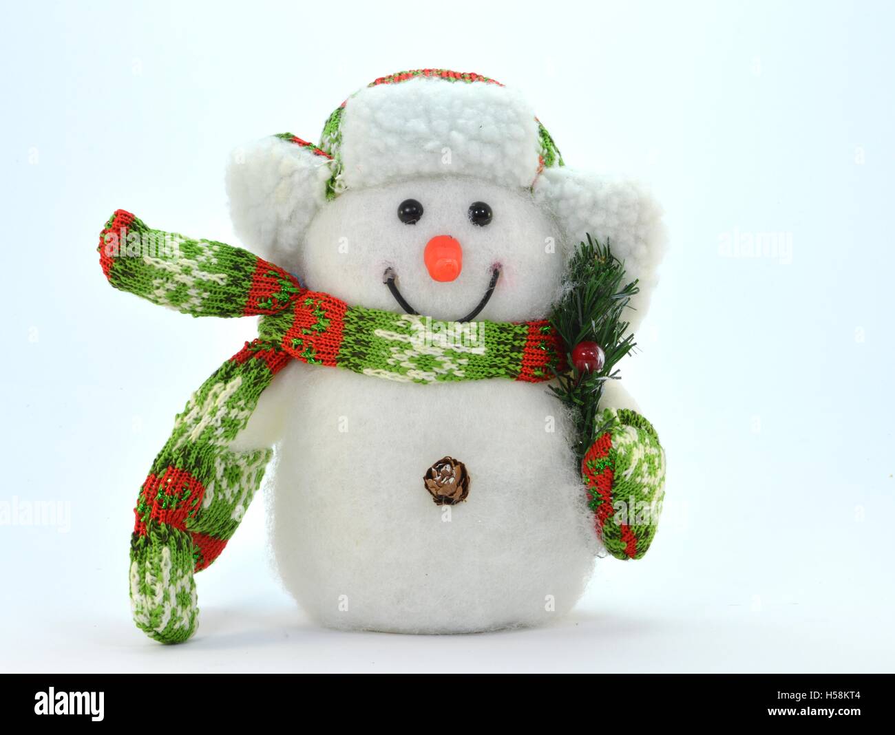 Snowman with a branch and a green and red scarf Stock Photo - Alamy