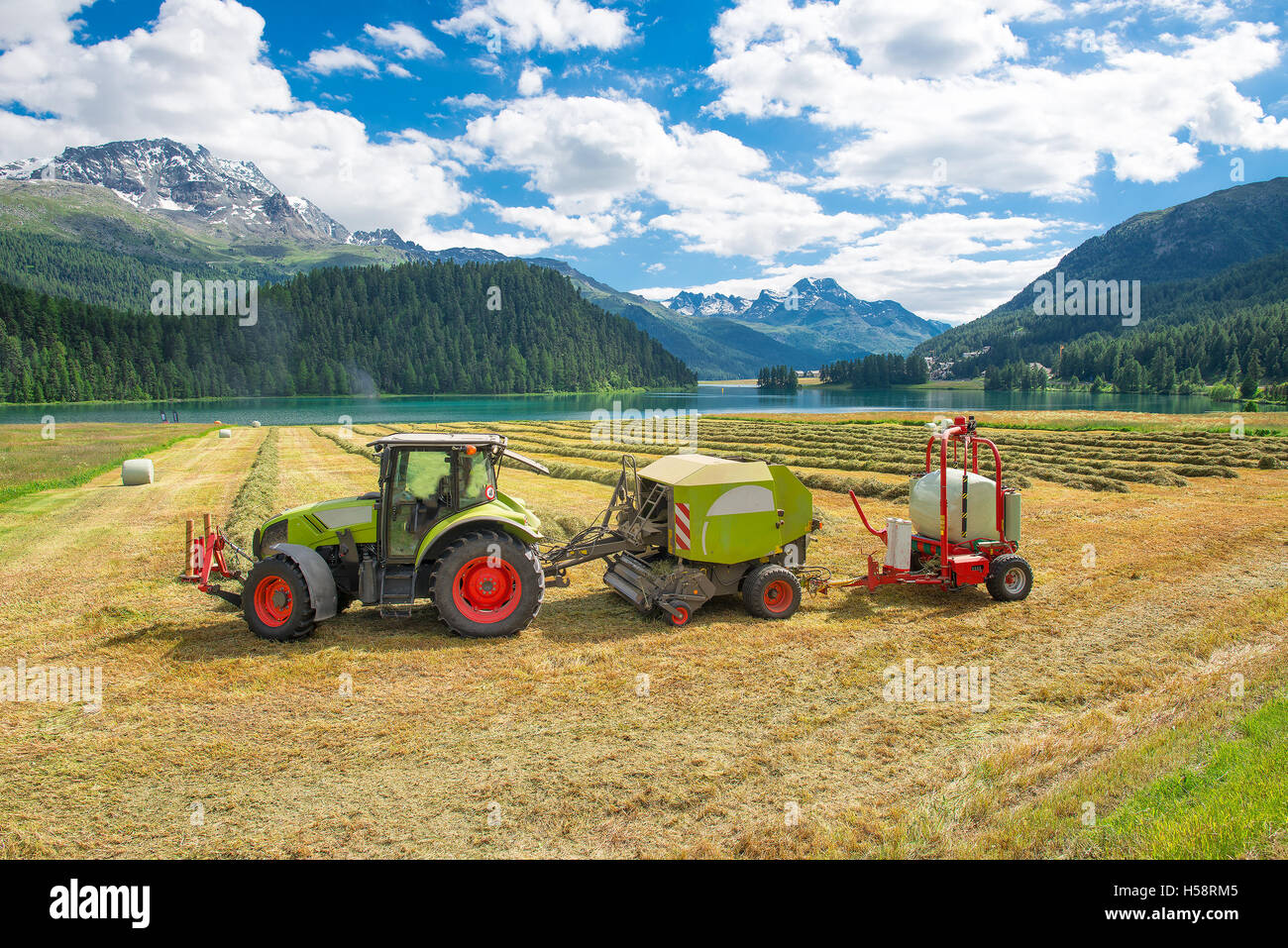 Tractor working the hay bales and creates fully automatic n meadows of ...