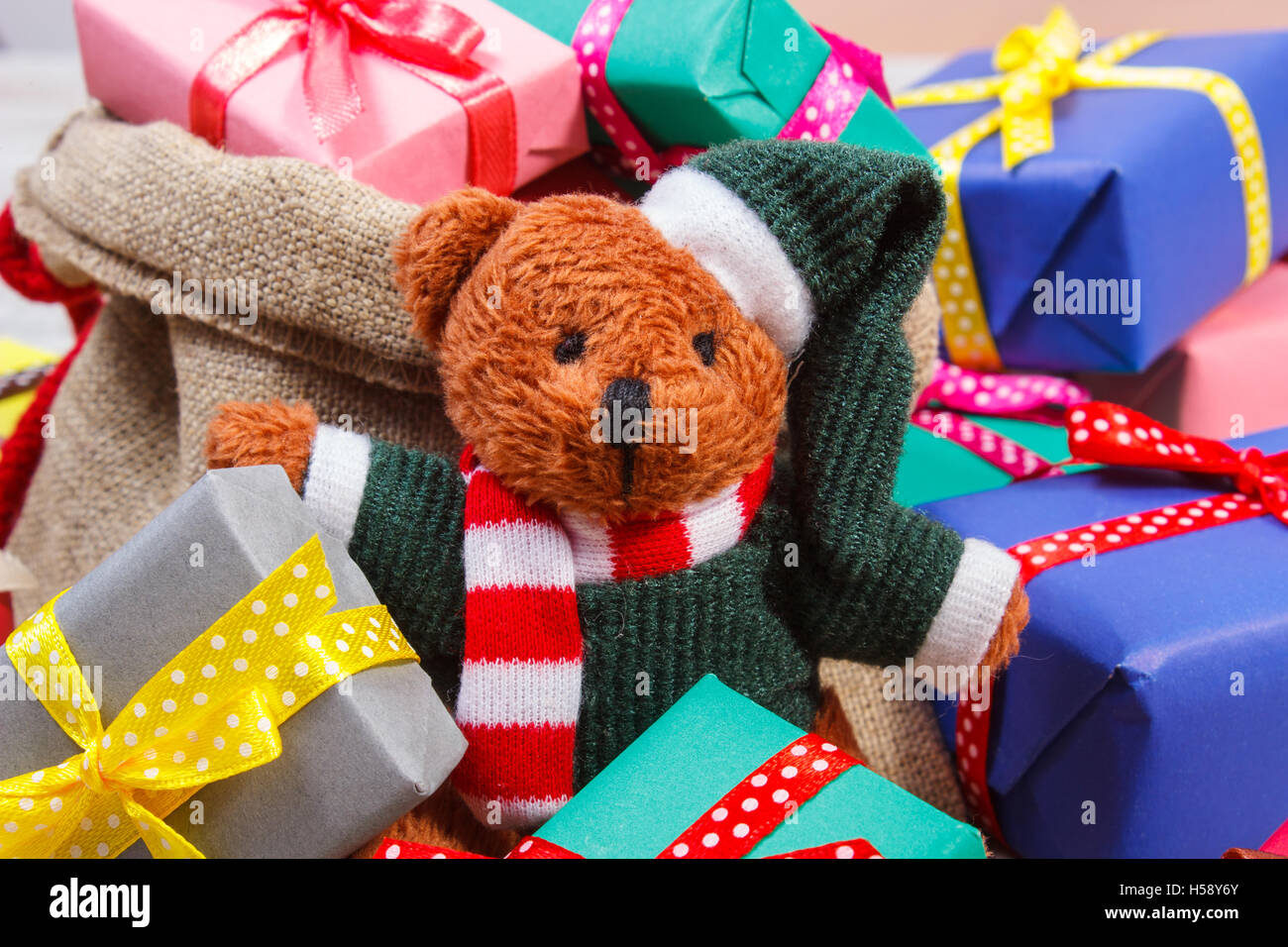 Fluffy teddy bear and heap of wrapped colorful gifts for Christmas ...