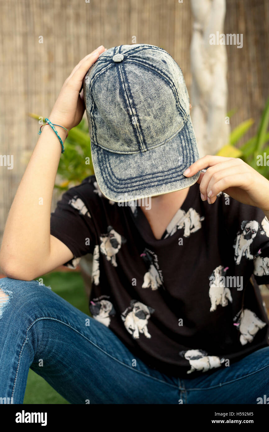 Girl with face covered with his Cap. Vertical capture Stock Photo - Alamy
