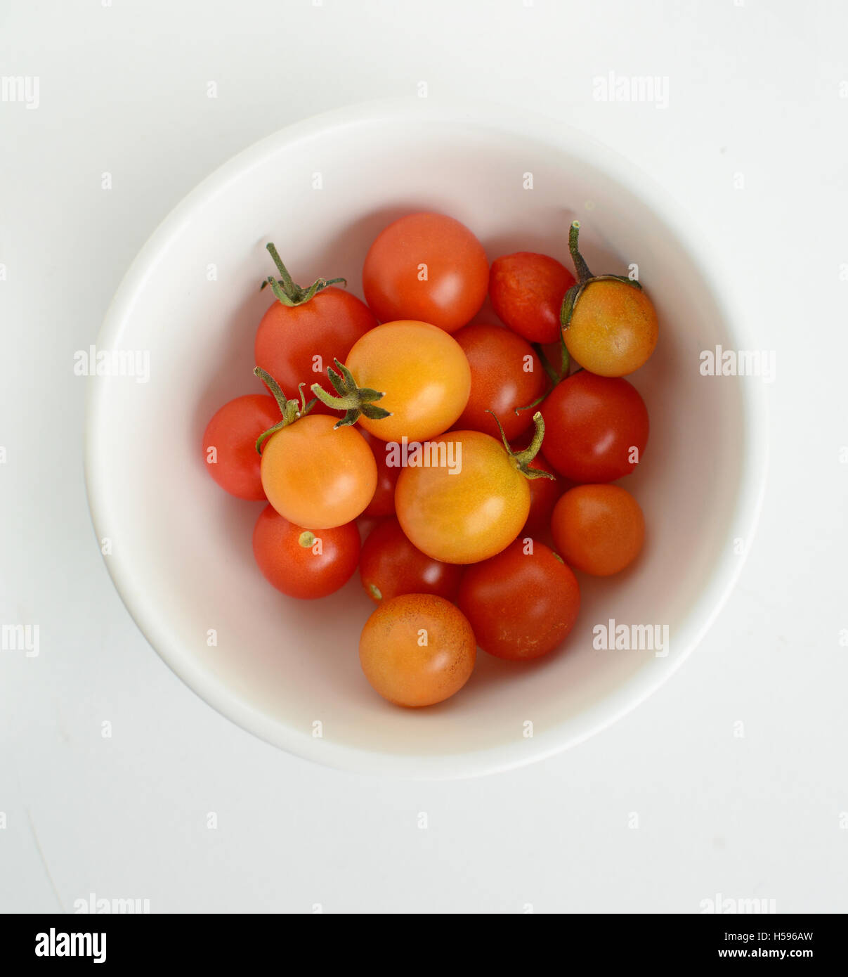 Last cherry tomatoes of the season in small round white bowl on white ...